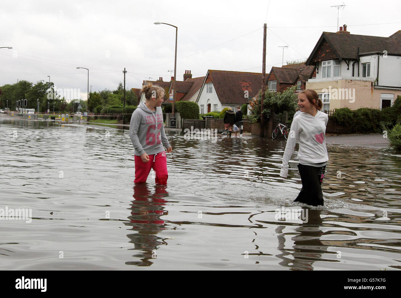 Locals make their way along a flooded road in Felpham near Bognor Regis ...
