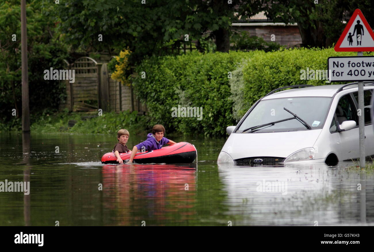 Children play in a dingy along a flooded road in Felpham near Bognor ...
