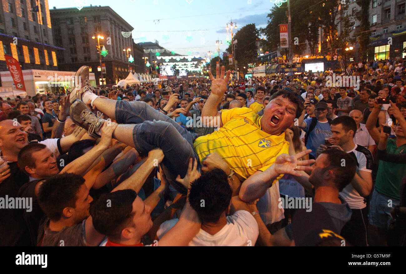 England fans lift up a Sweden fan as they mingle with each other ...