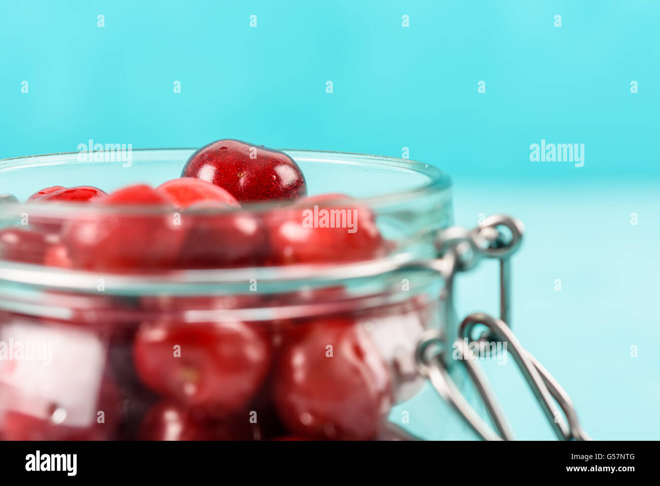 Jar Of Red Fresh Cherries On Turquoise Background Stock Photo - Alamy