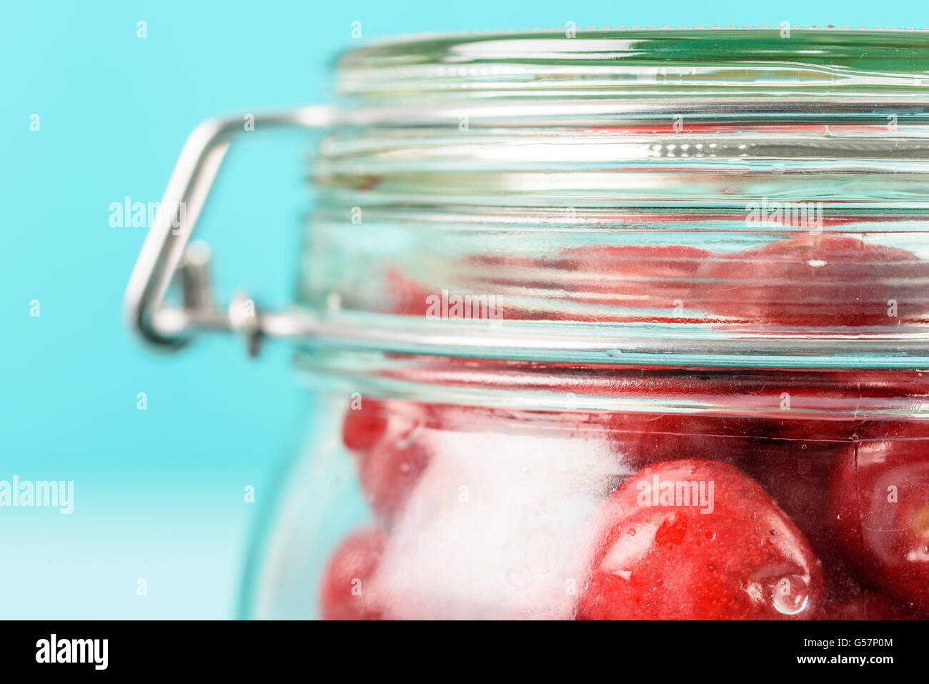 Jar Of Red Fresh Cherries On Turquoise Background Stock Photo - Alamy