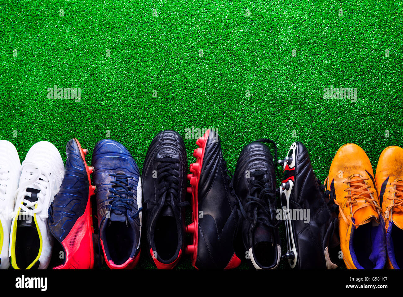 Various cleats against green artificial turf, studio shot Stock Photo ...