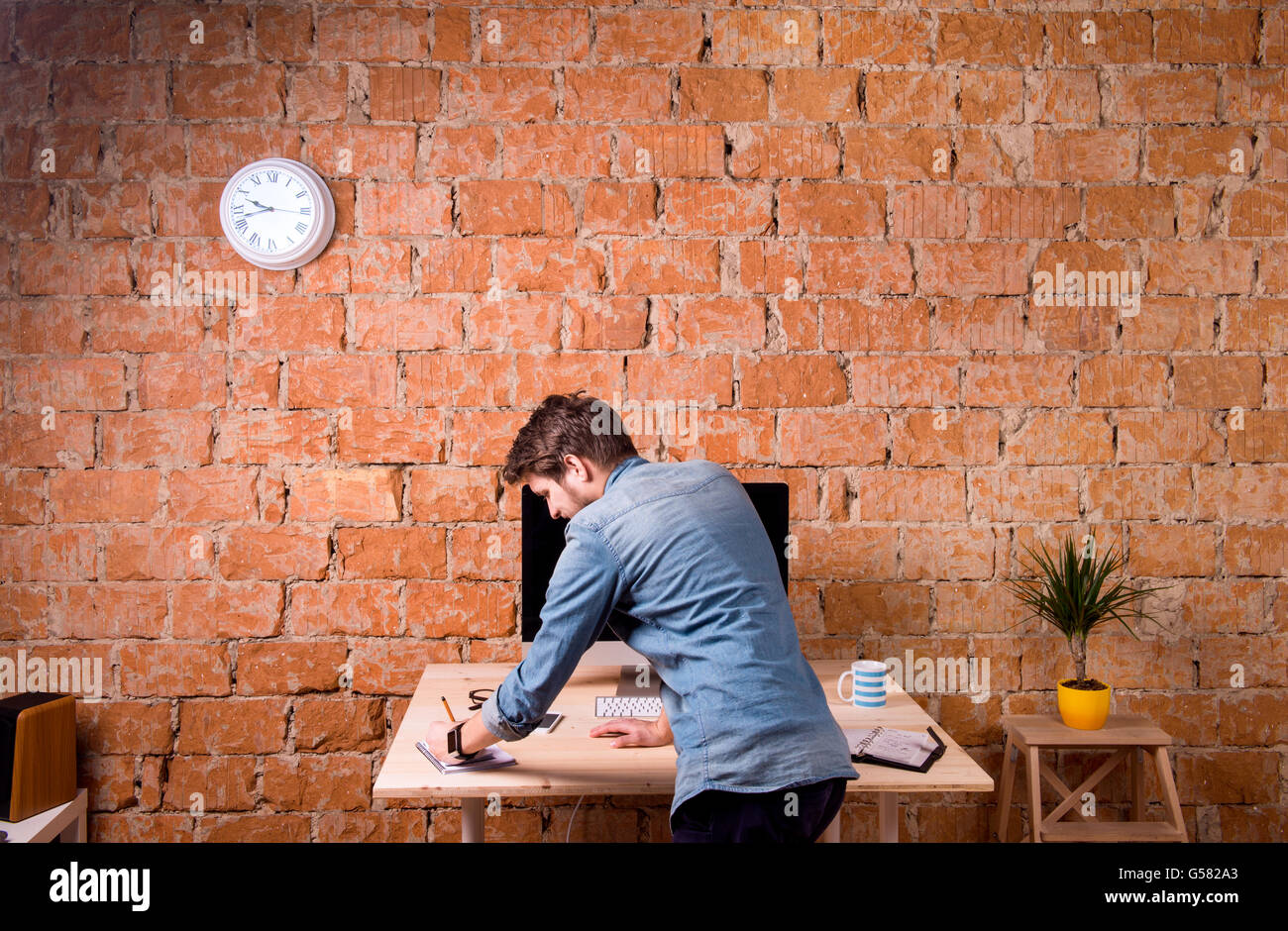 Business person standing at office desk working, rear view Stock Photo ...