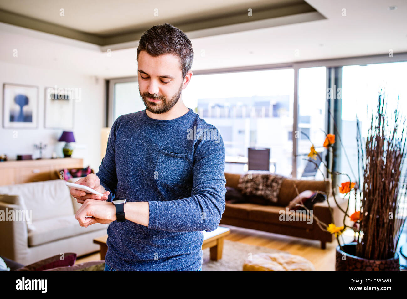 Man working from home using smartphone and smart watch Stock Photo - Alamy