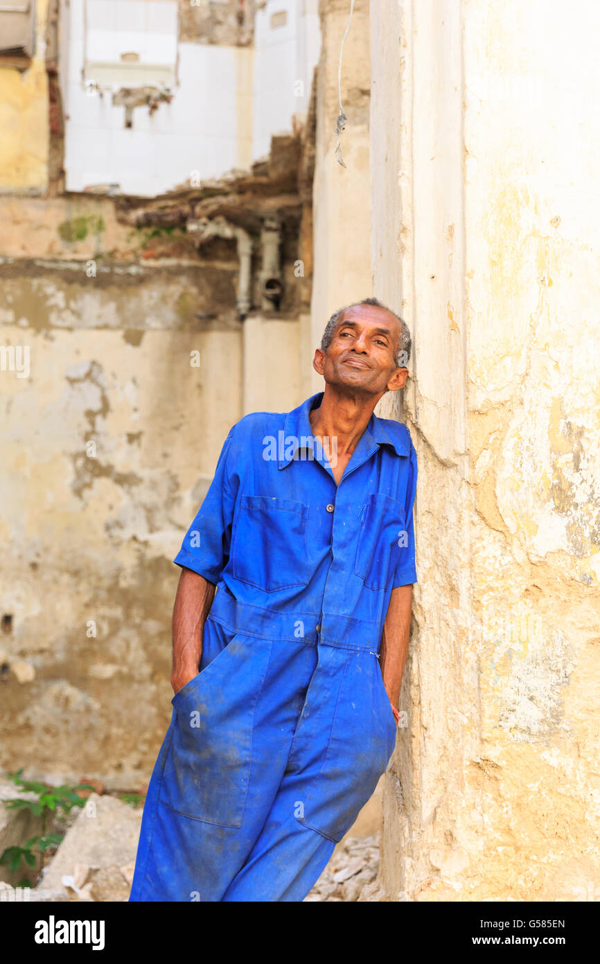 Cuban man leaning against wall in the ruins of an old building, La ...