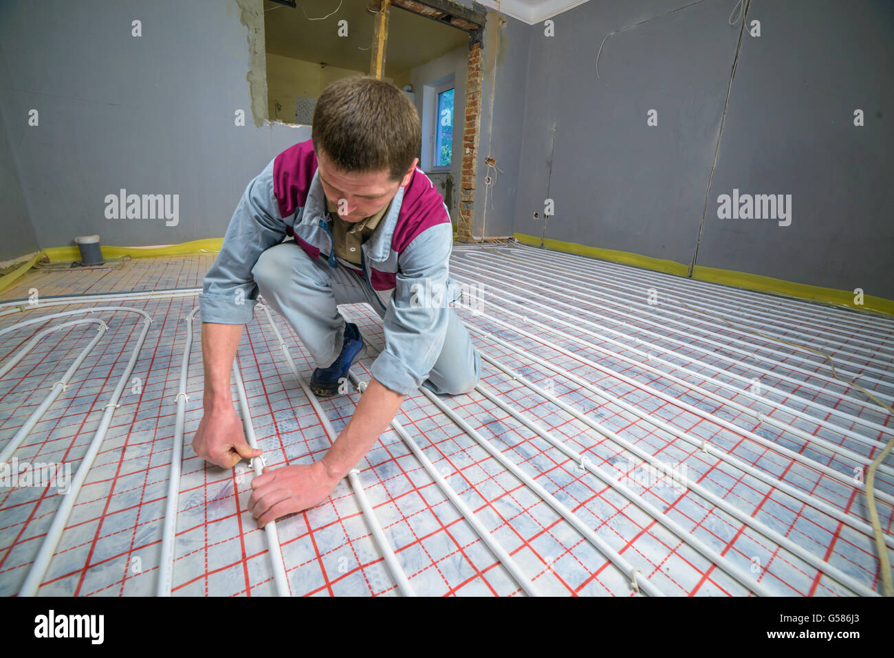 pipefitter installing system of heating Stock Photo - Alamy