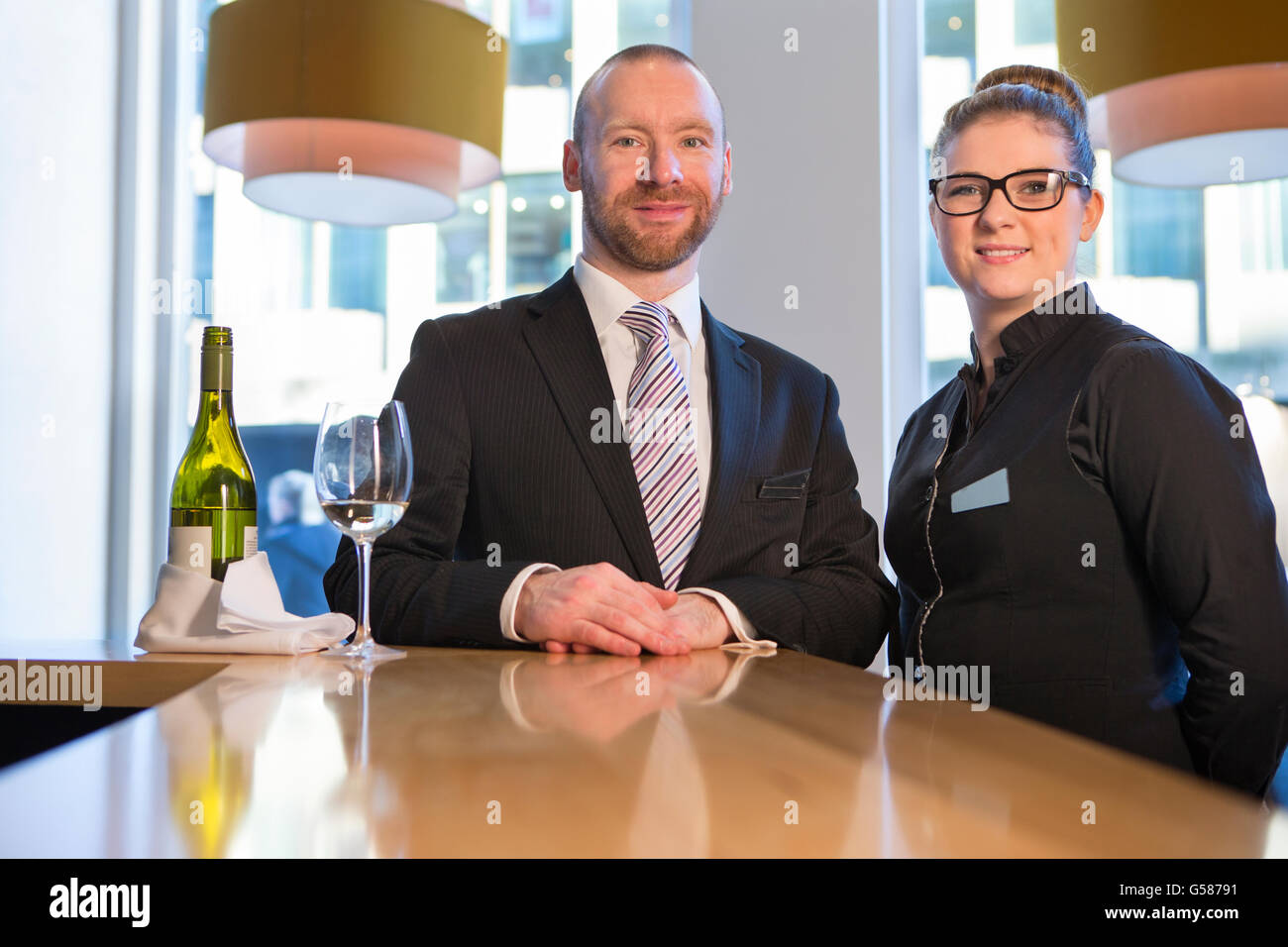 Bar manager with a member of staff. They are smiling for the camera ...