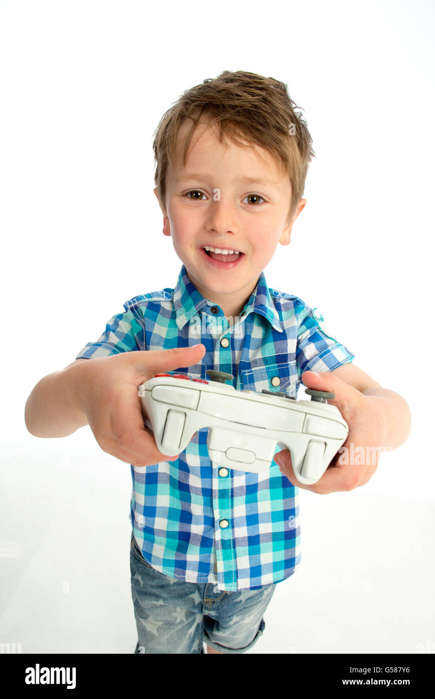 Young boy with a video game controller. He is standing against a white ...