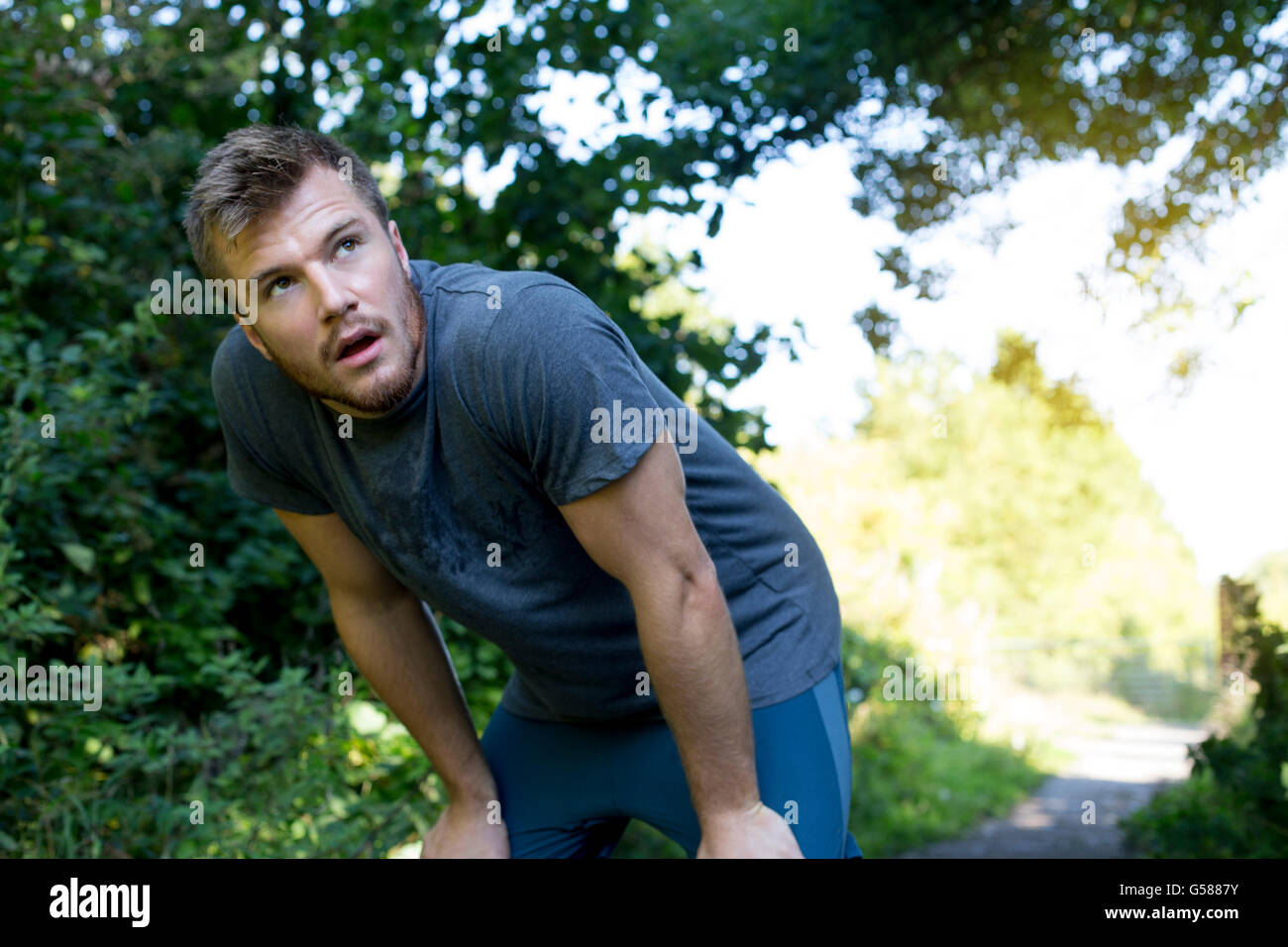Young man having a quick break from his run Stock Photo - Alamy