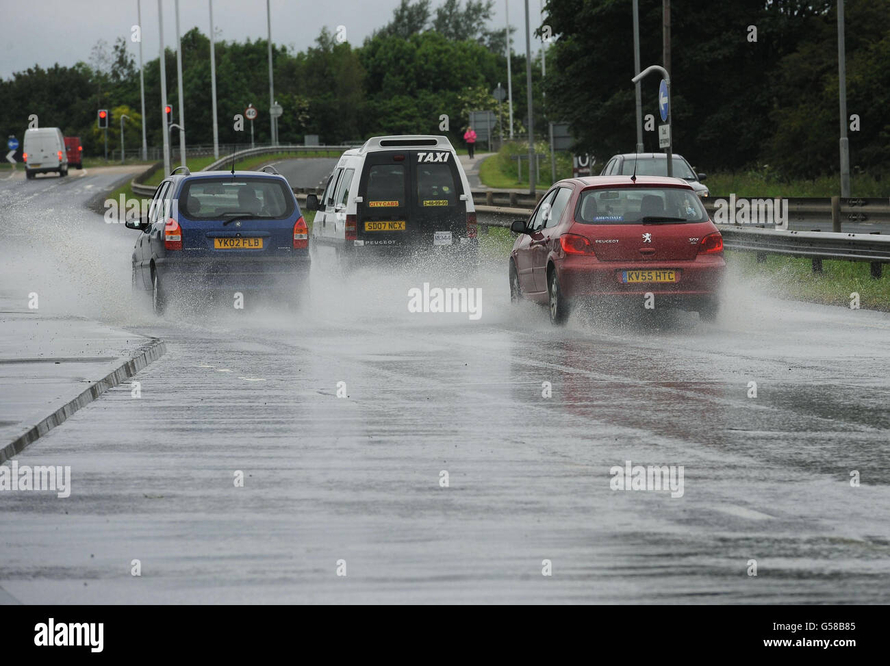 Cars splash through remaining flood water on the A63 outside Leeds ...