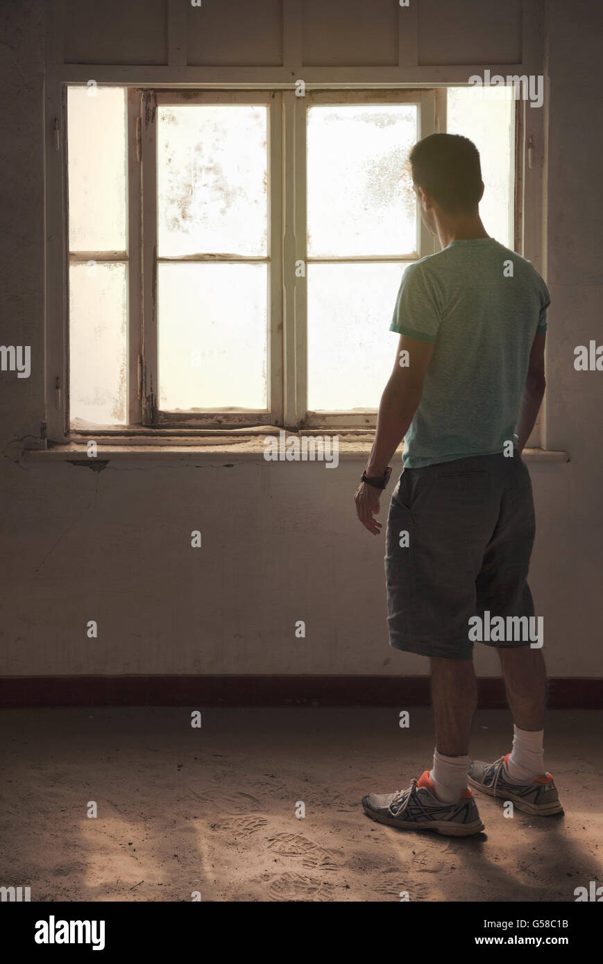 Man Standing At Derelict Window Stock Photo - Alamy
