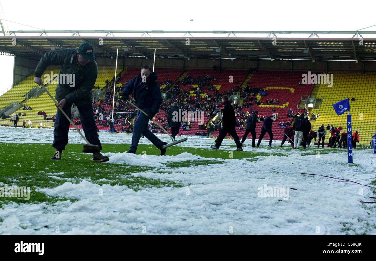 Ground staff clear snow from the pitch at Vicarage Road, before the ...