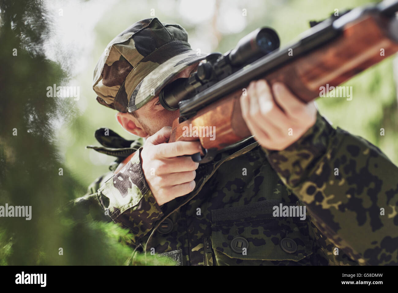 soldier or hunter shooting with gun in forest Stock Photo - Alamy
