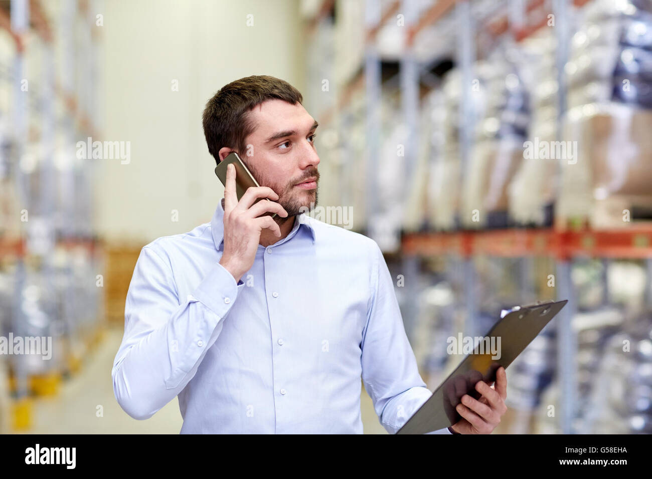 man with clipboard and smartphone at warehouse Stock Photo - Alamy