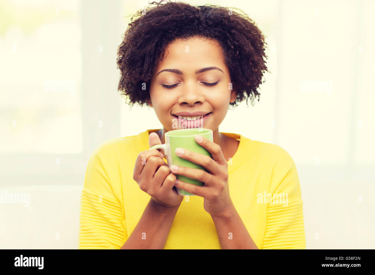 happy african american woman drinking from tea cup Stock Photo - Alamy