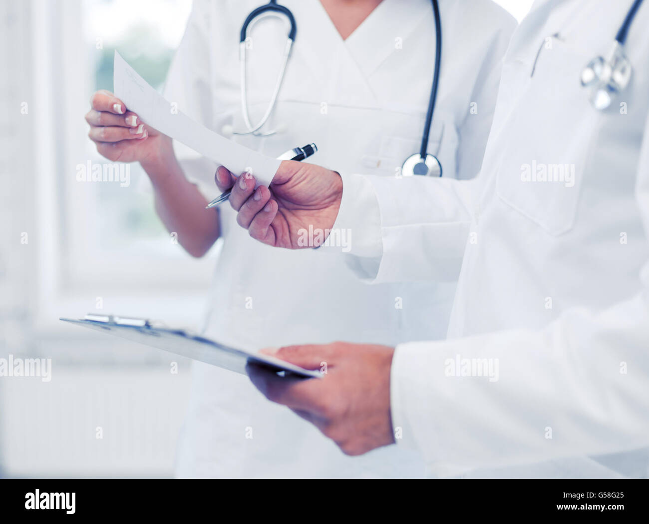 two doctors writing prescription Stock Photo - Alamy