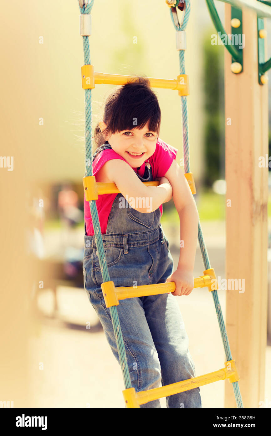 happy little girl climbing on children playground Stock Photo - Alamy