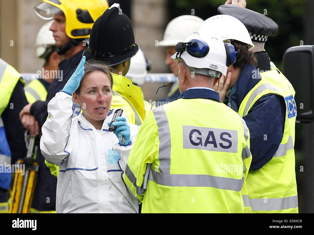 A forensic officer talks to Gas engineers close to the scene of a ...