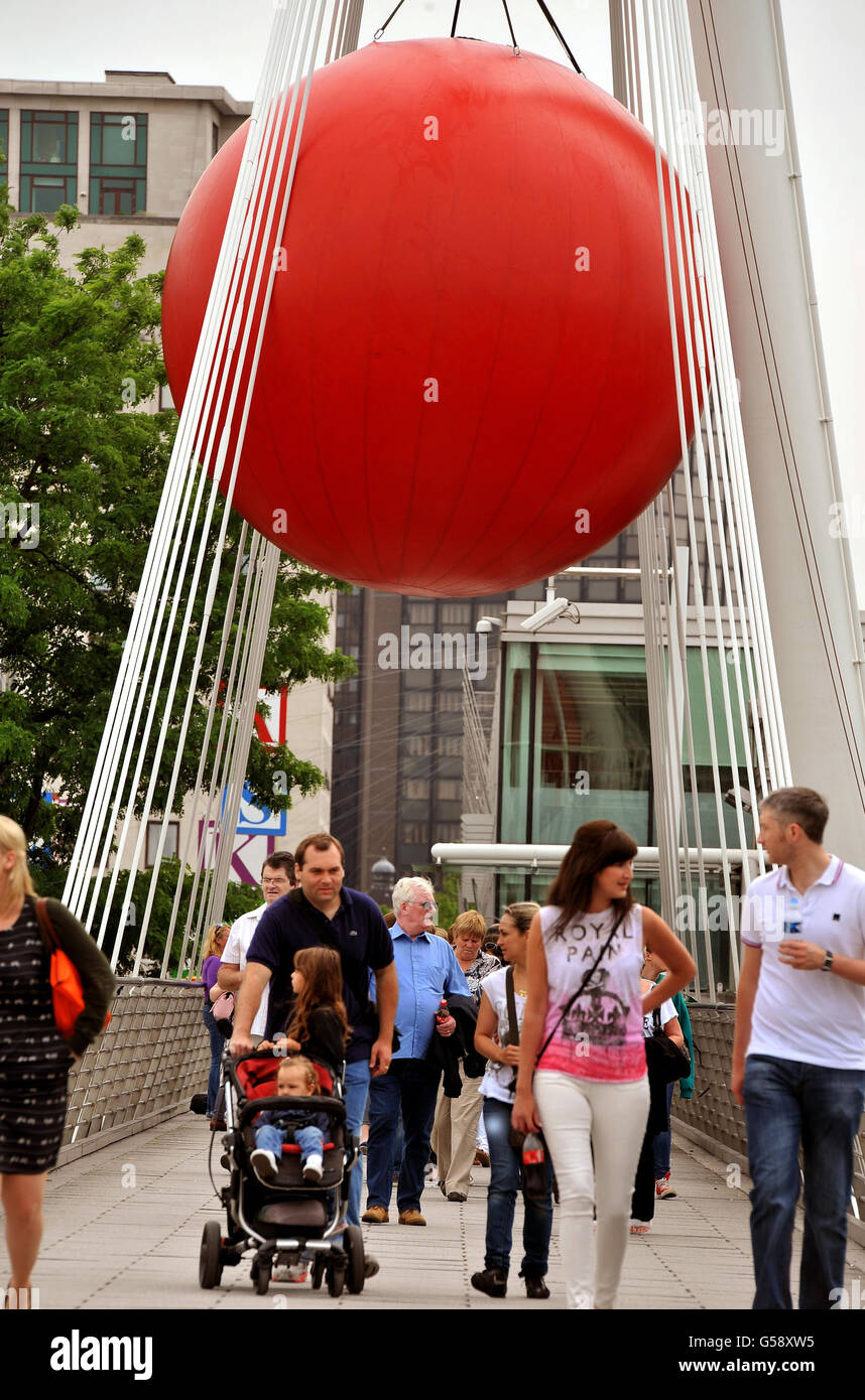 A giant fifteen foot inflatable red ball is suspended above the Golden ...