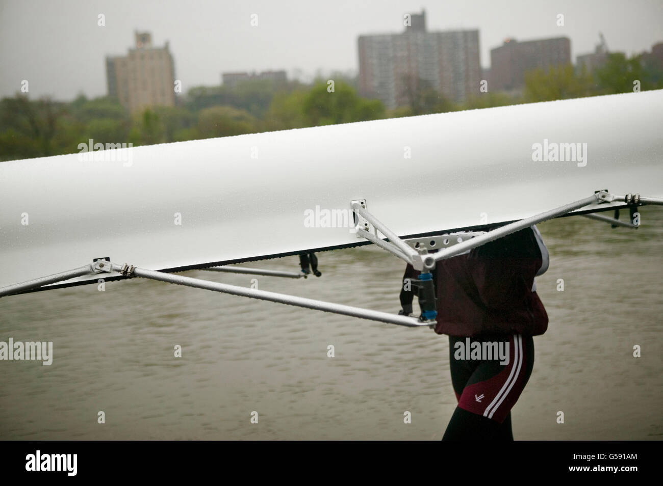 A rower helps carry a boat back to the Peter Jay Sharp boathouse after ...