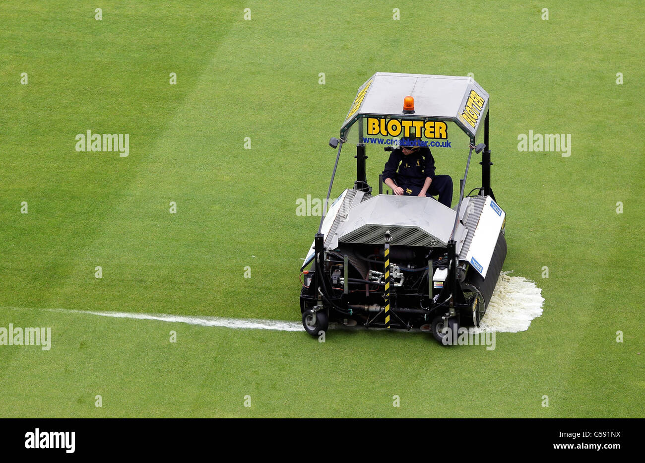 Ground staff clear up water from the outfield before the Third One Day ...