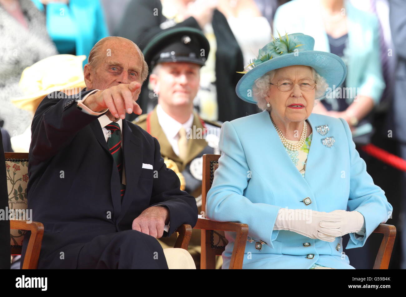 Queen Elizabeth II and the Duke of Edinburgh watch a flotilla of boats ...