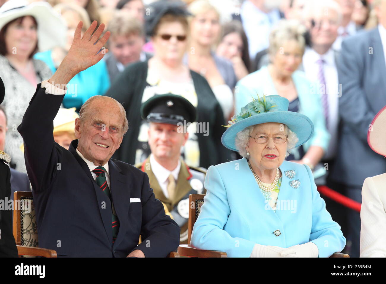 Queen Elizabeth II and the Duke of Edinburgh watch a flotilla of boats ...