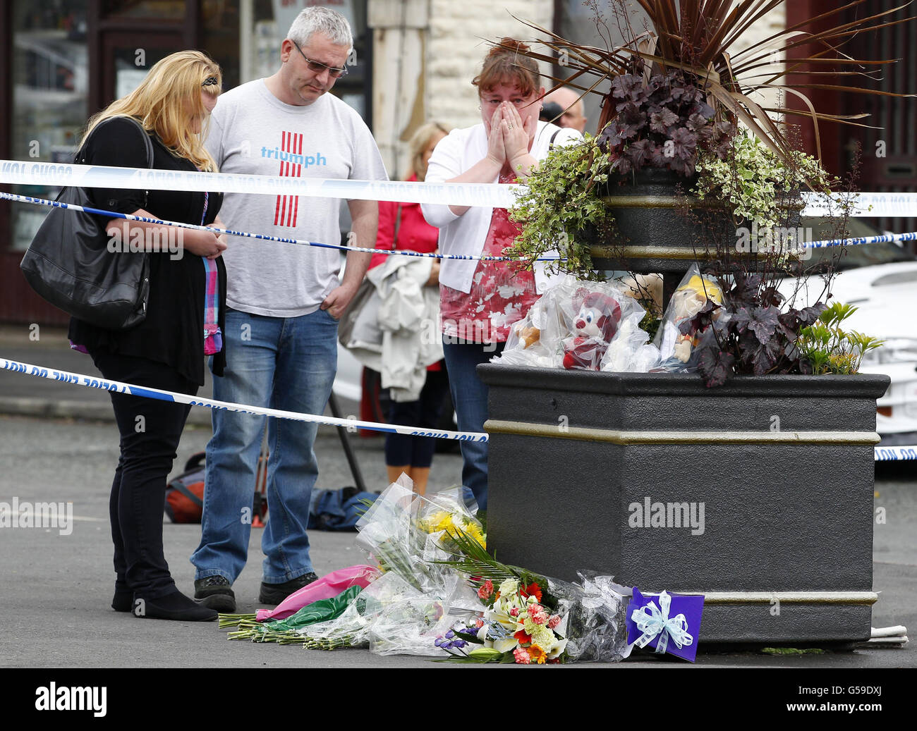 Family friends of Jamie Heaton (names not given) stand alongside floral ...