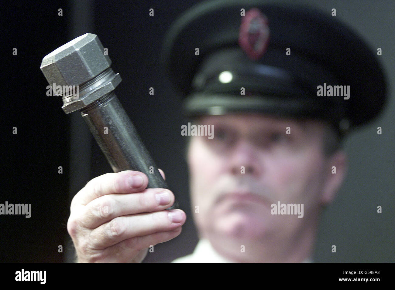 An RUC officer holds one of the explosive devices known as "pipe bombs ...