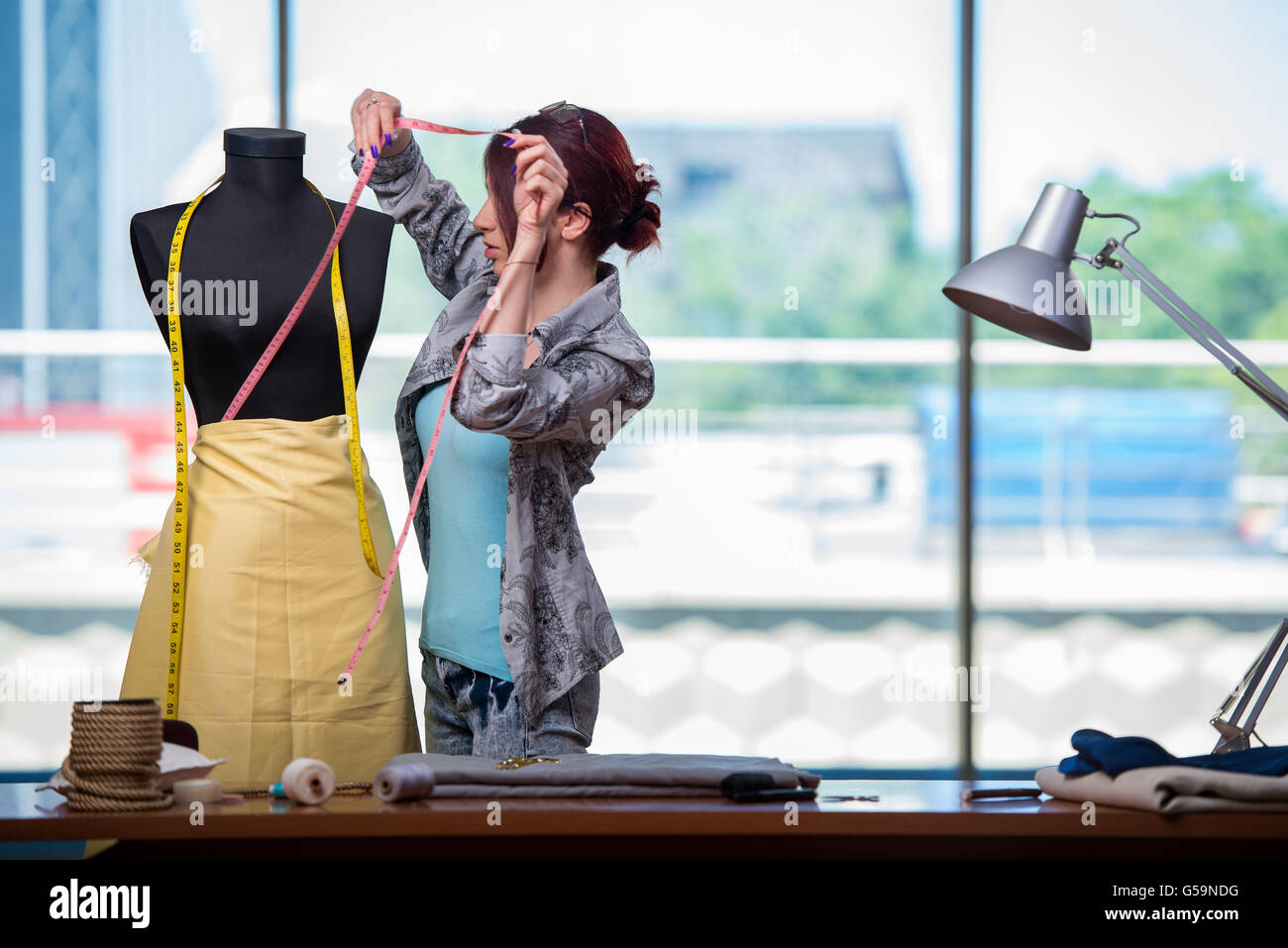 Woman tailor working at her desk Stock Photo - Alamy