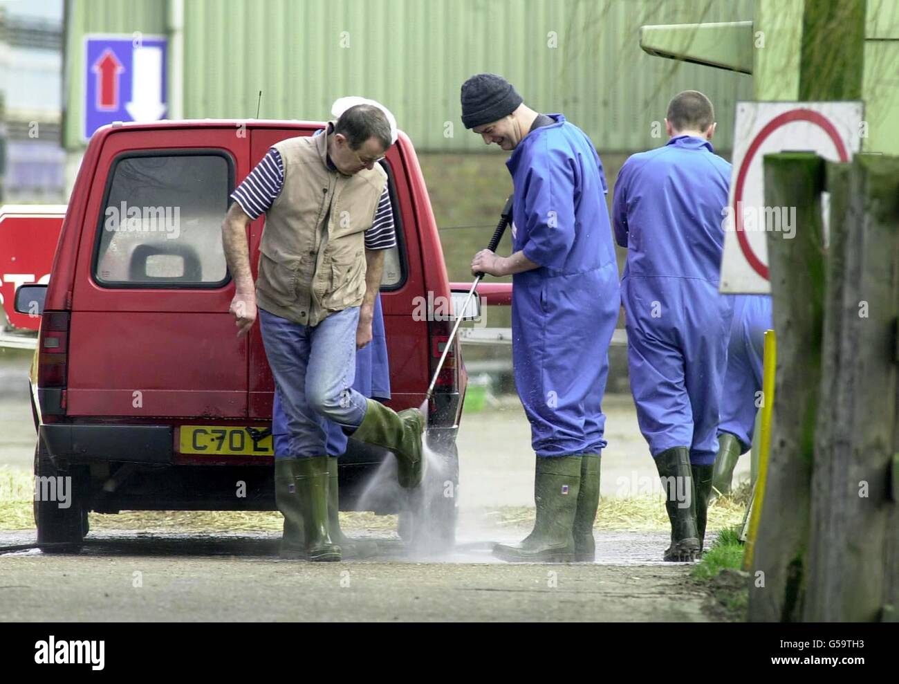Workers at the Cheale meat farm, have their boots sprayed before ...