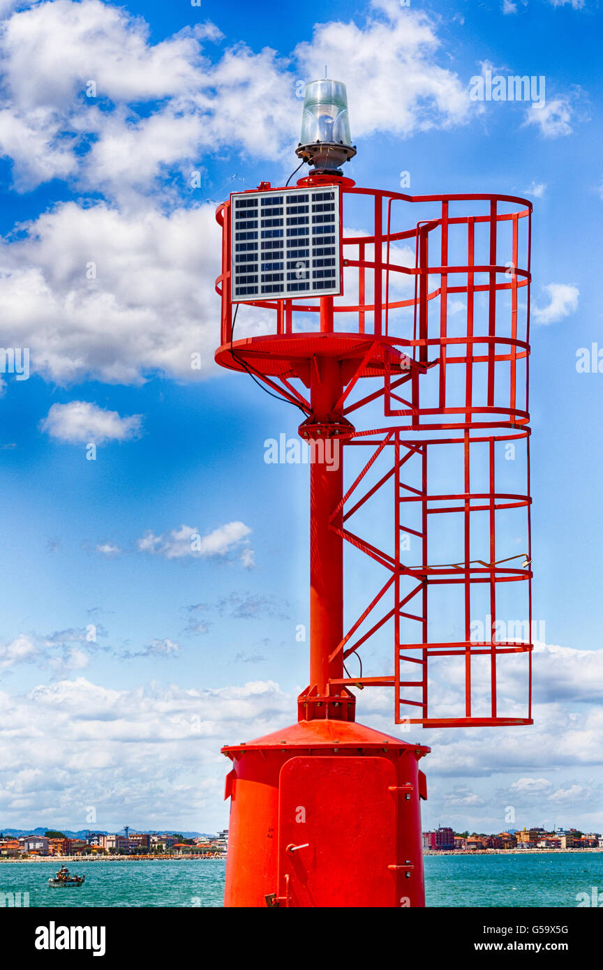red metal lighthouse powered by solar panel with the Adriatic coast and ...