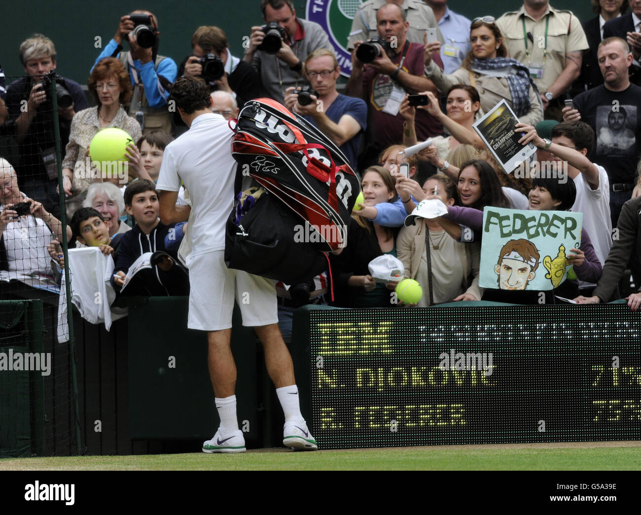 Switzerland's Roger Federer signs autographs after defeating Serbia's ...