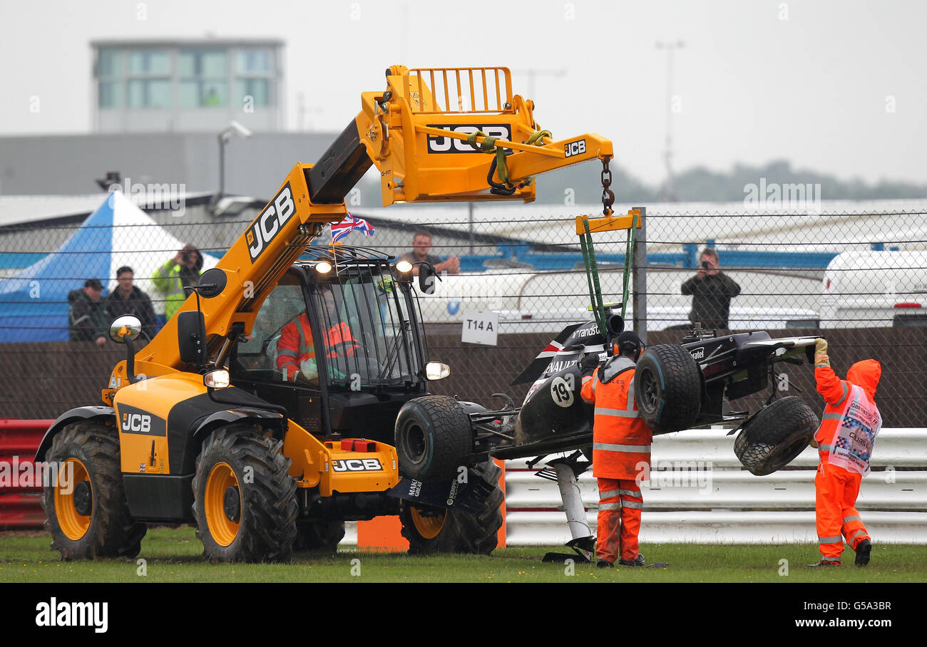 The Williams of Bruno Senna is winched away after crashing during ...
