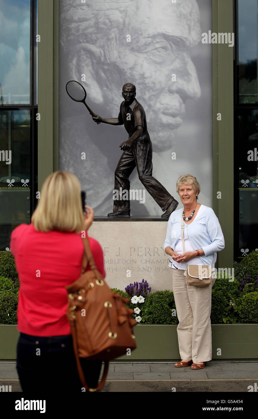 Fans pose with the Fred Perry statue outside Centre Court during day ...