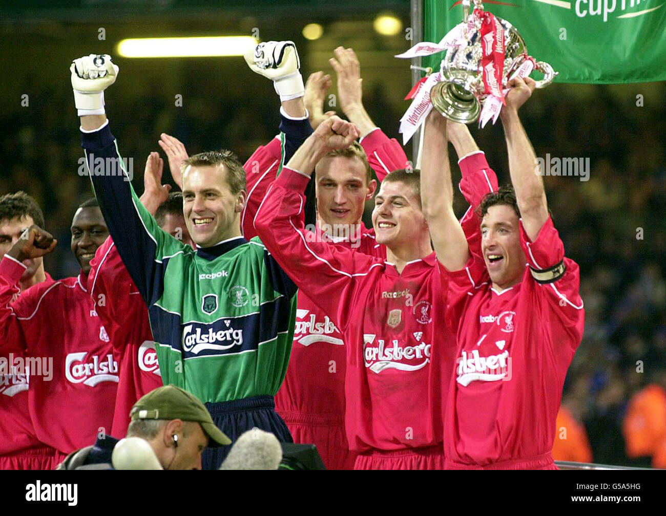Liverpool captain Robbie Fowler (far right) and Steven Gerrard holds up ...