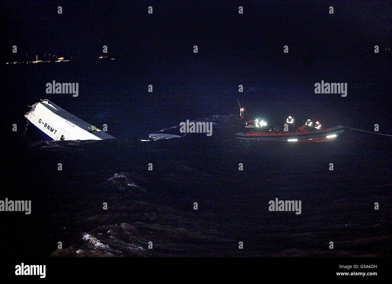 A lifeboat crew with divers onboard watch the wreckage of a Loganair ...