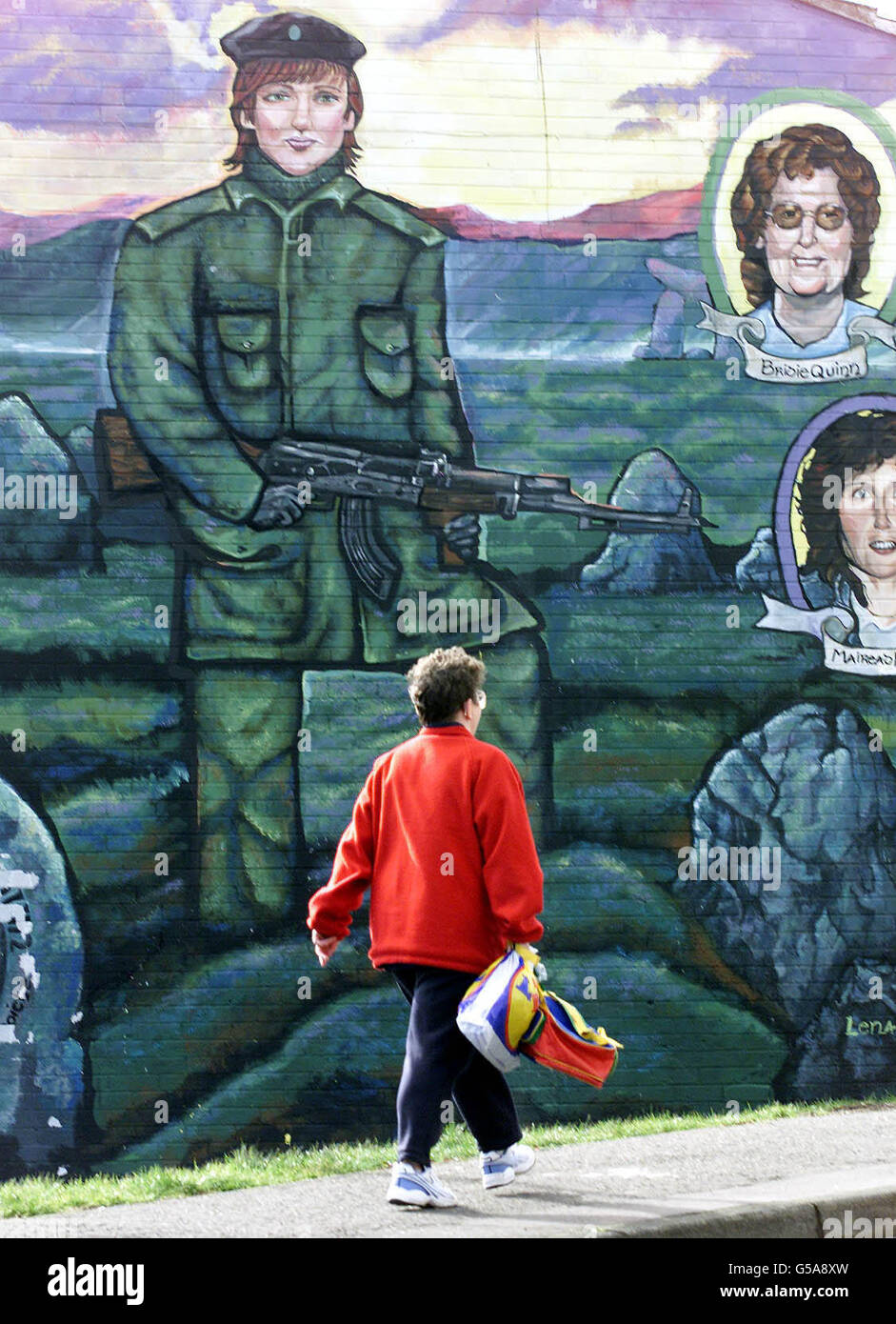 A woman walks past an IRA Mural in west Belfast. The IRA renewed ...