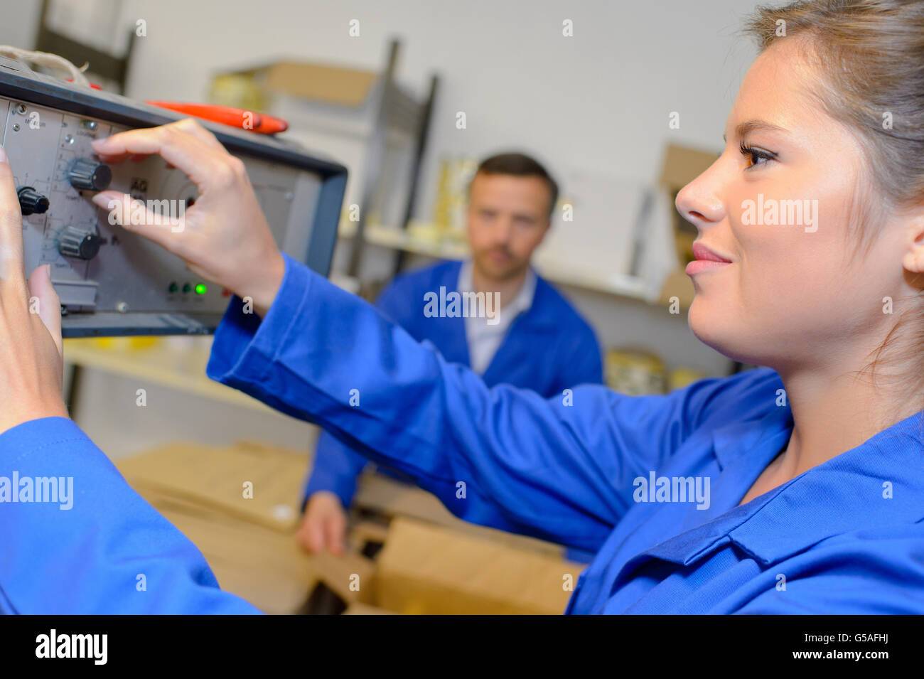 Worker adjusting dial on machine Stock Photo - Alamy