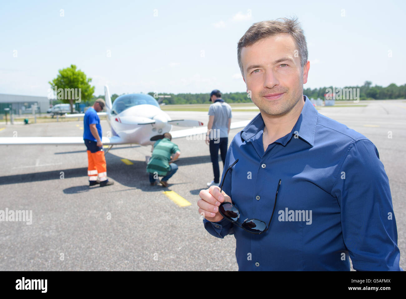 Portrait of man on runway with light aircraft Stock Photo - Alamy