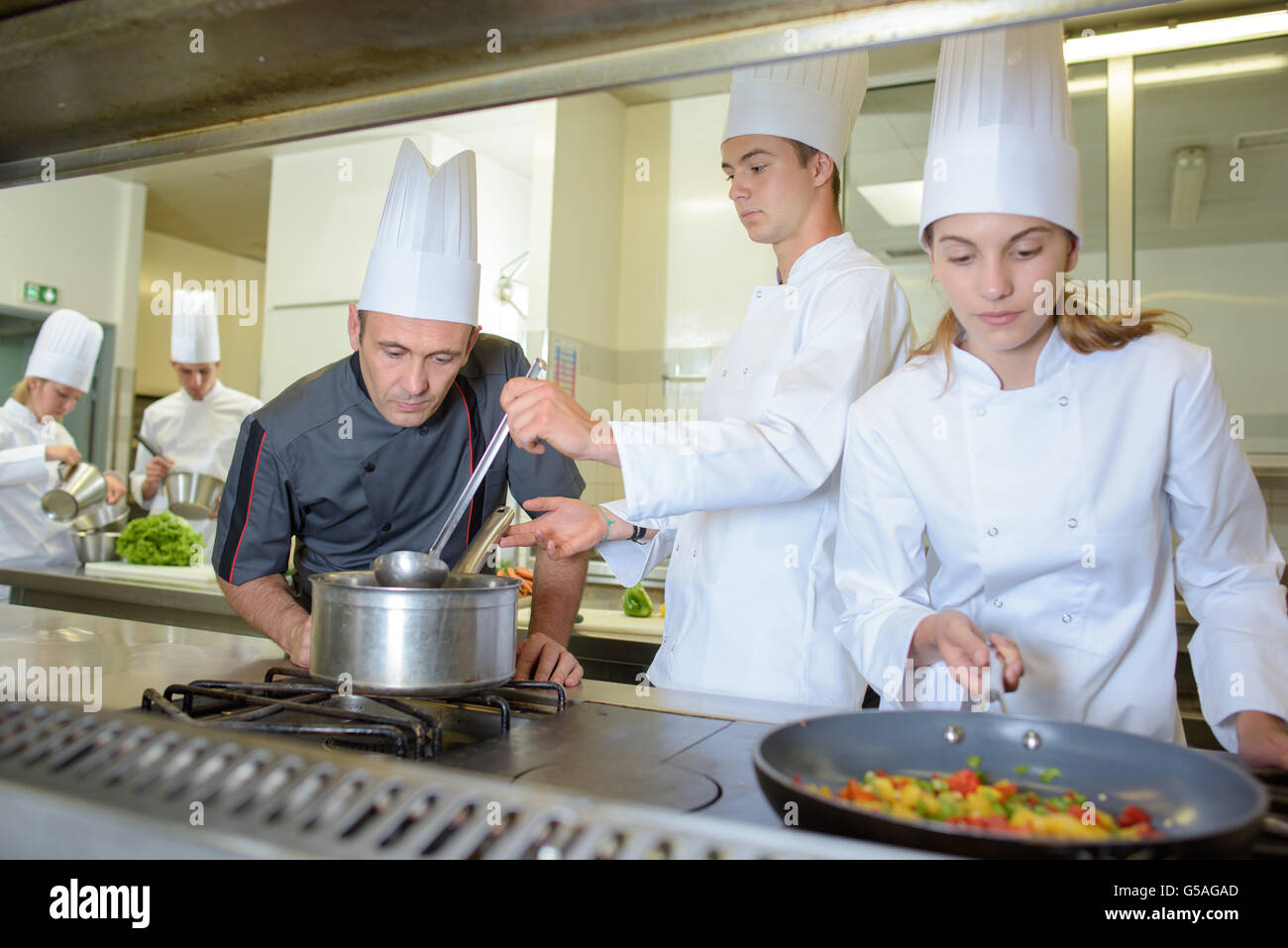 Chef observing trainee cooks Stock Photo - Alamy