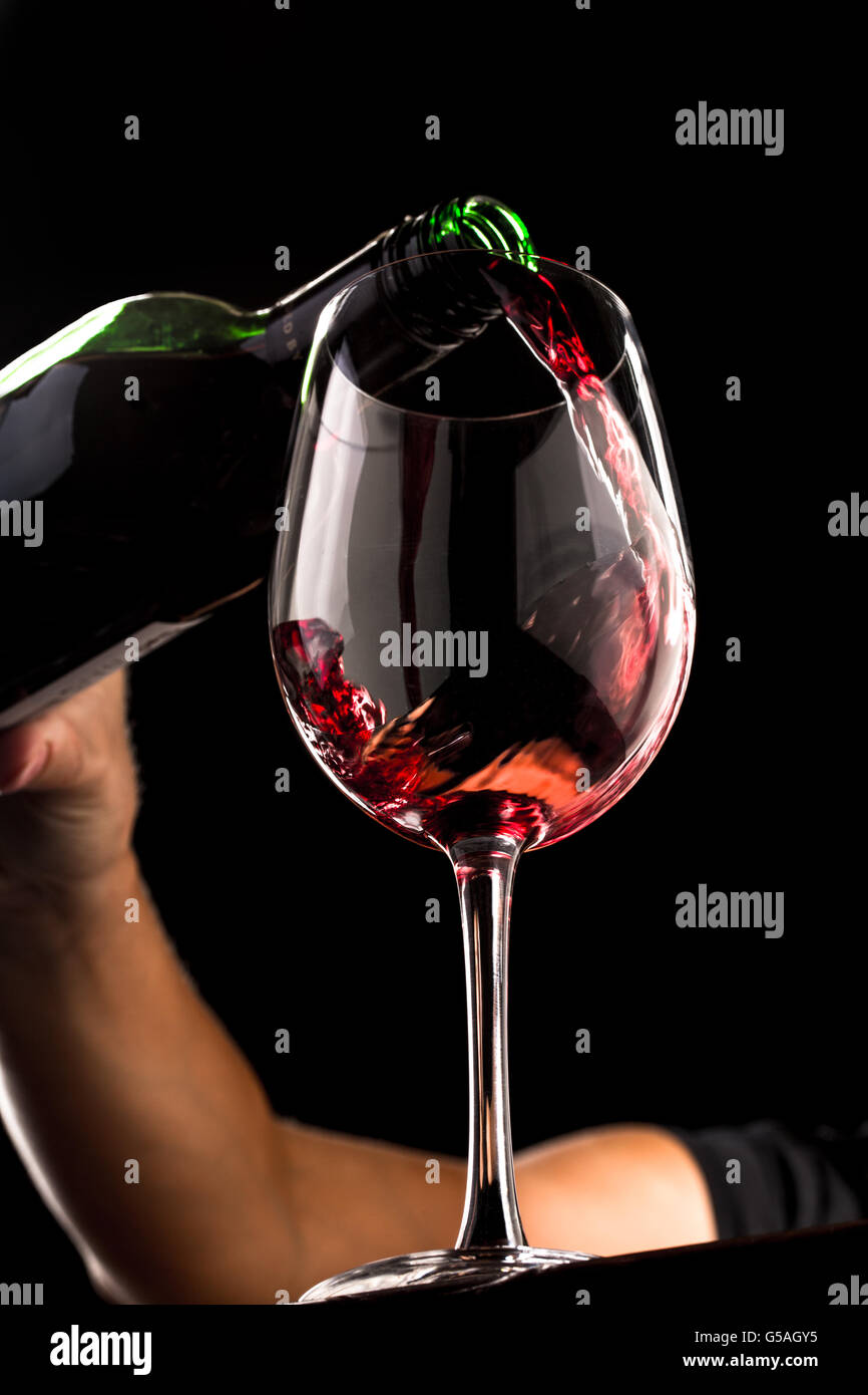 Girls hand pouring red wine into the glass Stock Photo - Alamy