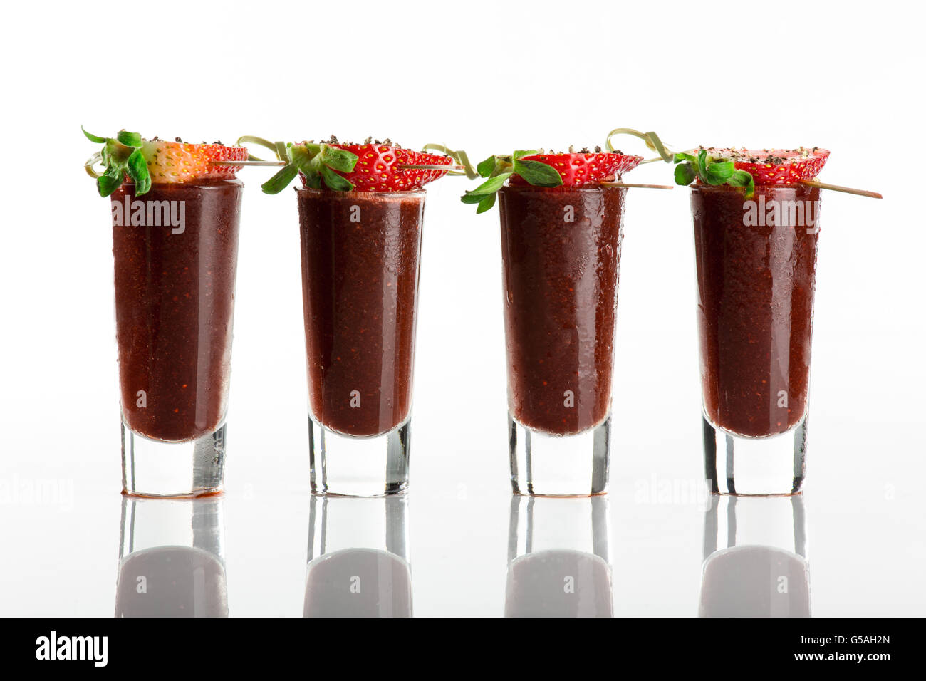 Four berry shots isolated on white background Stock Photo - Alamy