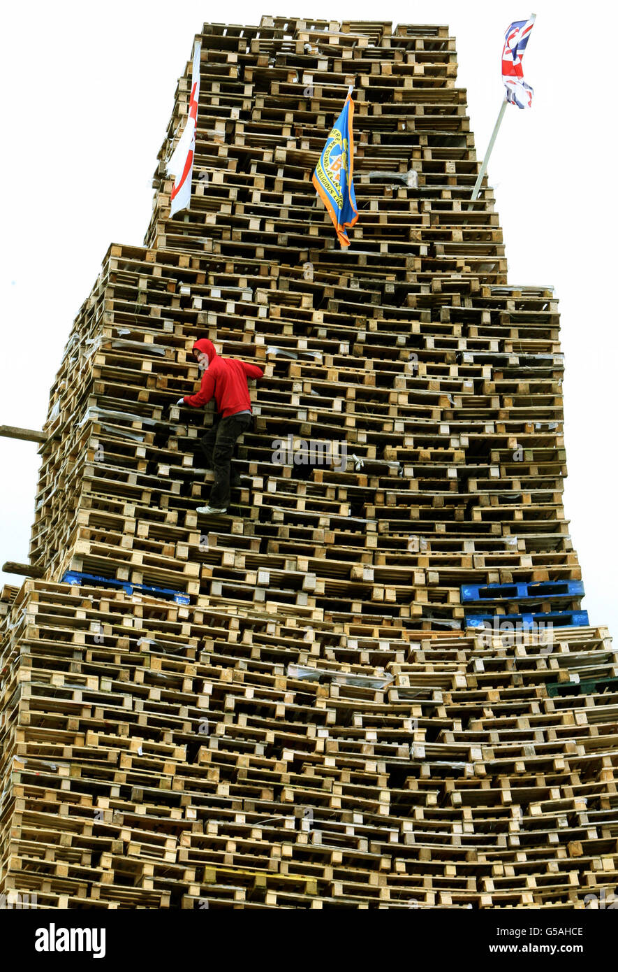 A man climbs one of the biggest 11th night bonfires at New Mossley on ...