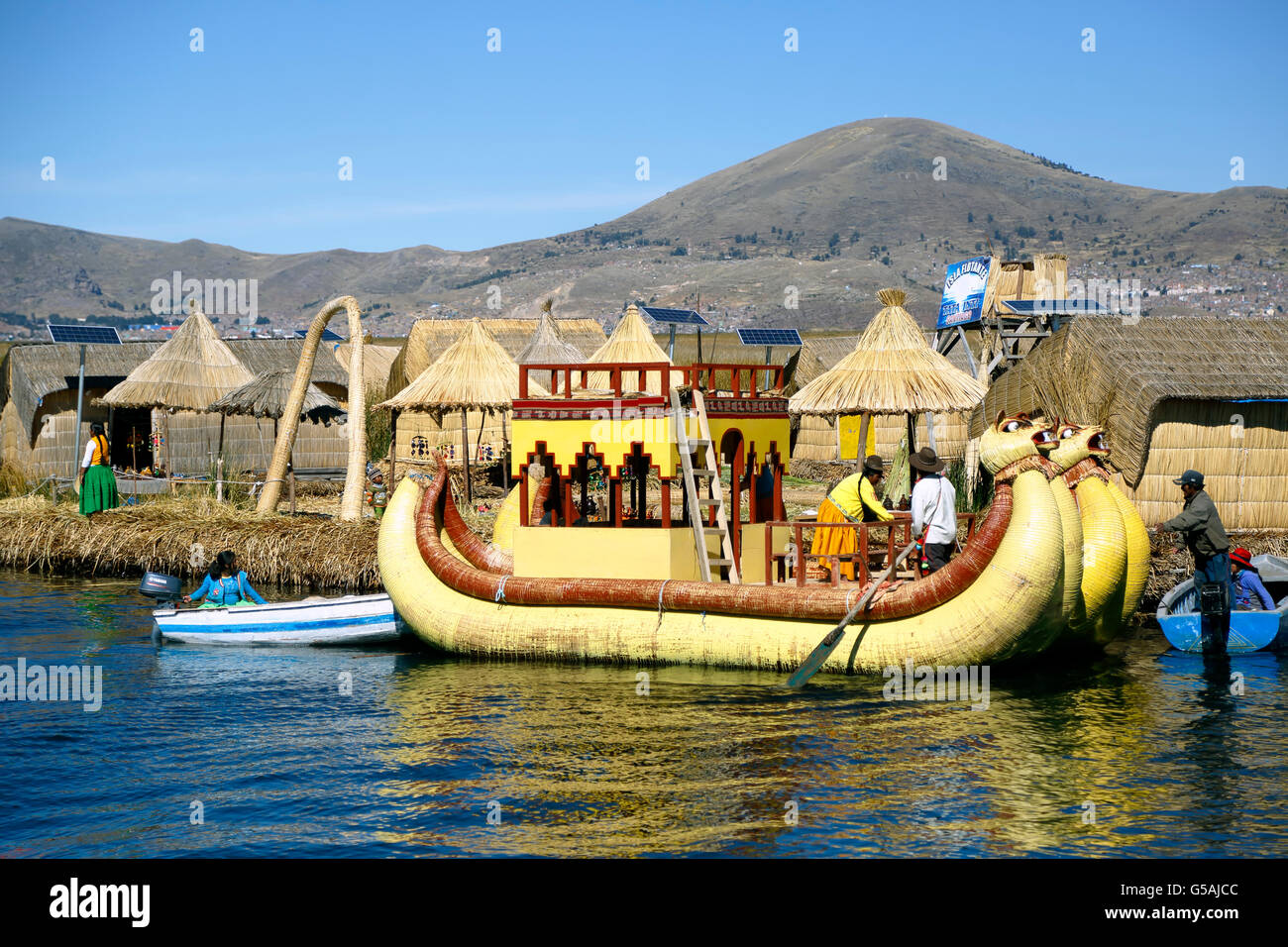 Yellow totora reed boat and houses on totora reed island, Uros Islands ...