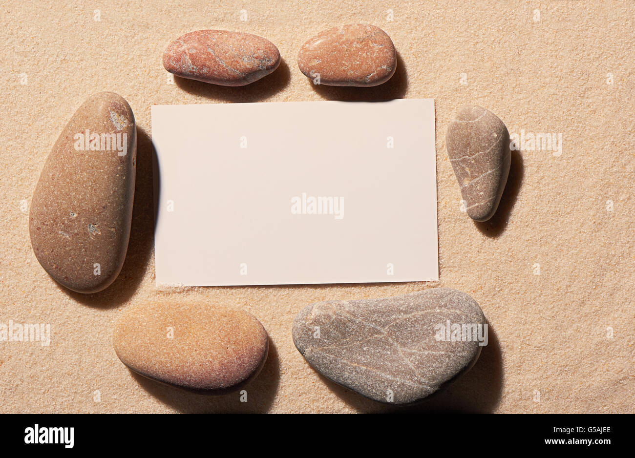 Rectangular frame of six small and large sea stones with blank white ...