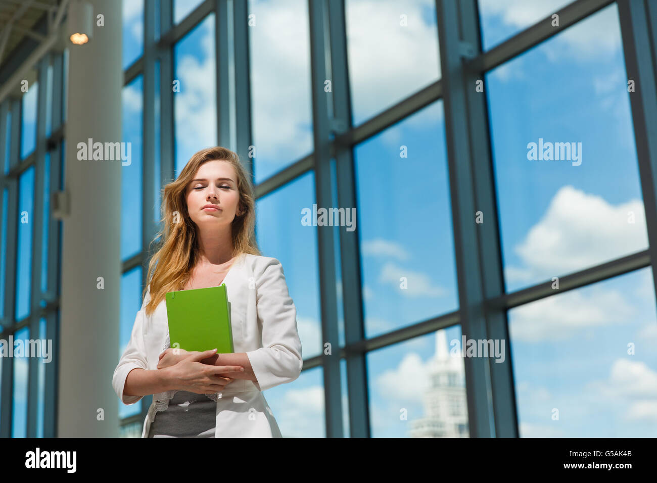 Young beautiful woman holding green notebook Stock Photo - Alamy