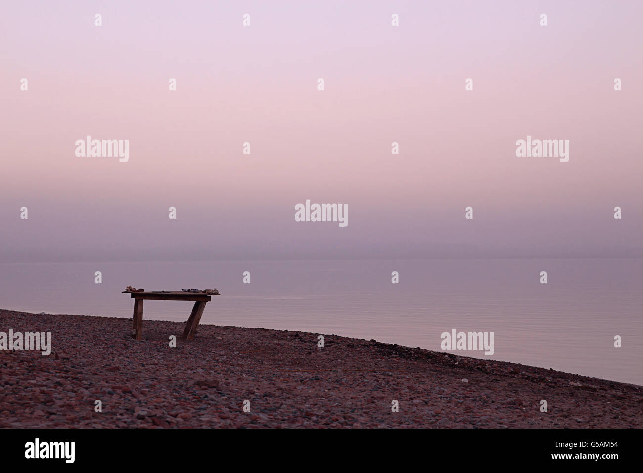 Wooden table at seashore against sunset background Stock Photo - Alamy