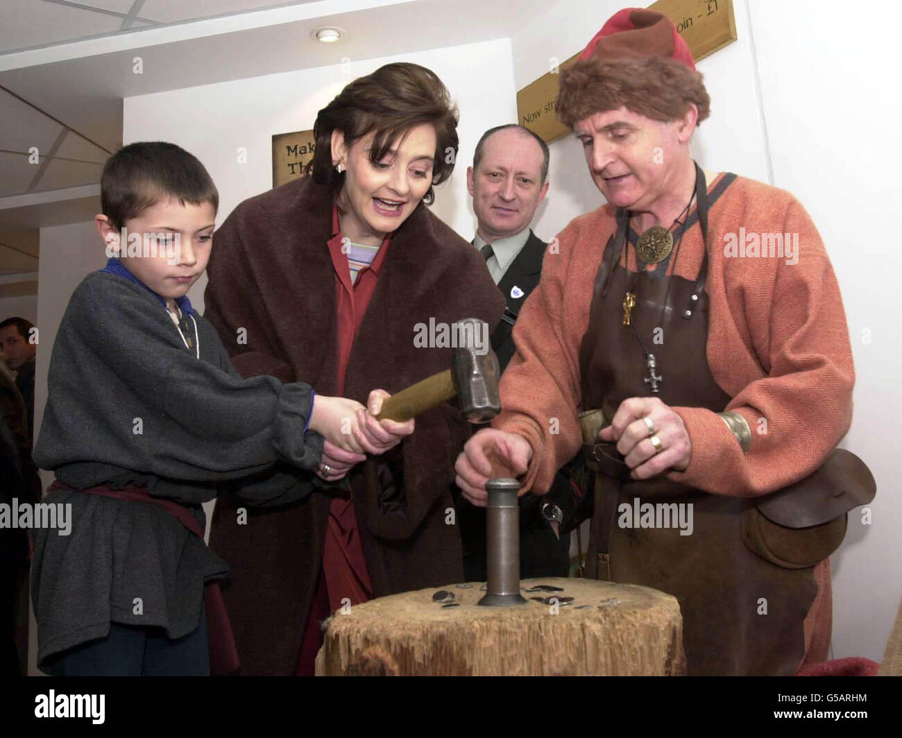 Cherie Blair strikes a coin with the help of nine-year-old Callum Wood ...