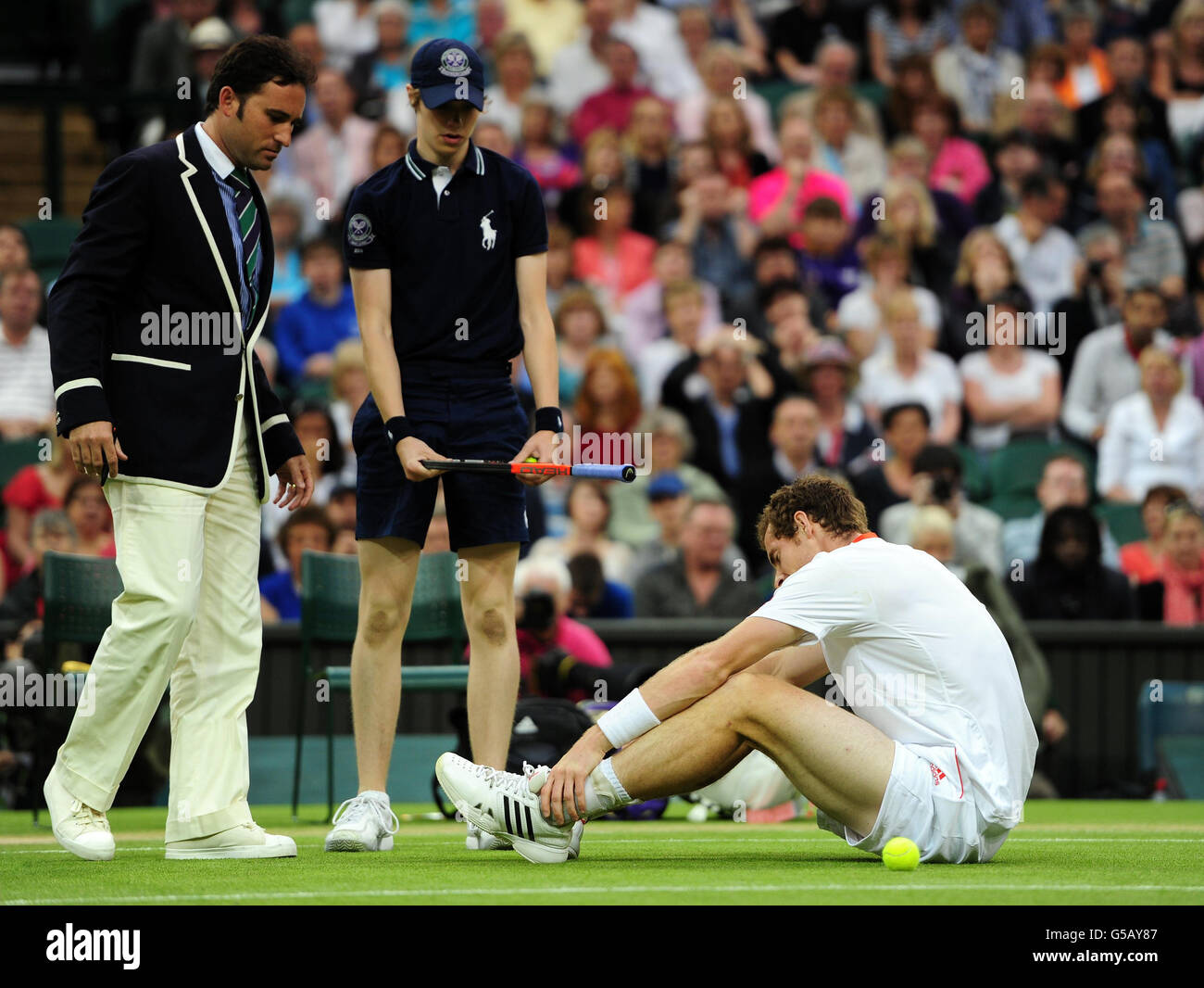 Great Britain's Andy Murray holds his ankle after falling in his match ...